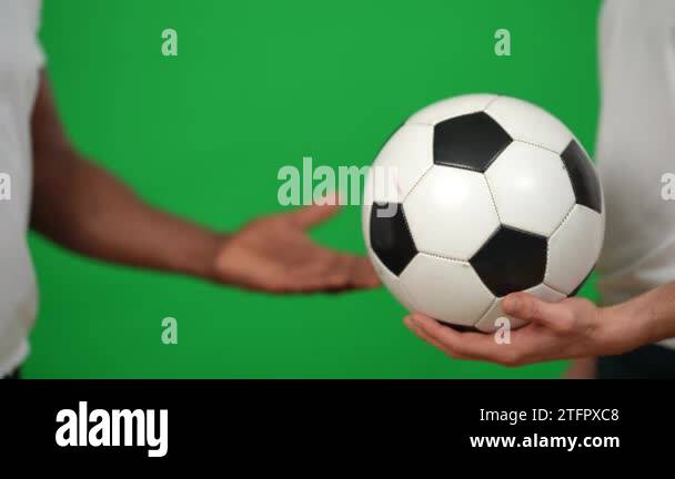 Close-up male Caucasian and African American hands passing football ...
