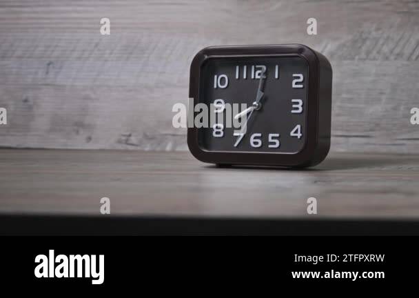 The pointer clock on wooden table shows time 8 oclock. Arrow brown ...