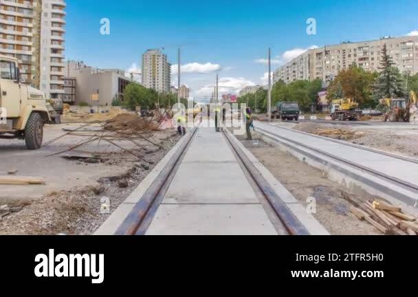 Workers do cleaning of the railway tram line after construction works ...
