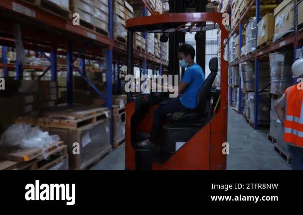 Business concept of 4k Resolution. An employee is driving a forklift in ...