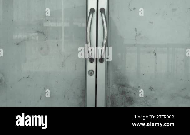 Dirty glass doors in abandoned old building store or supermarket ...
