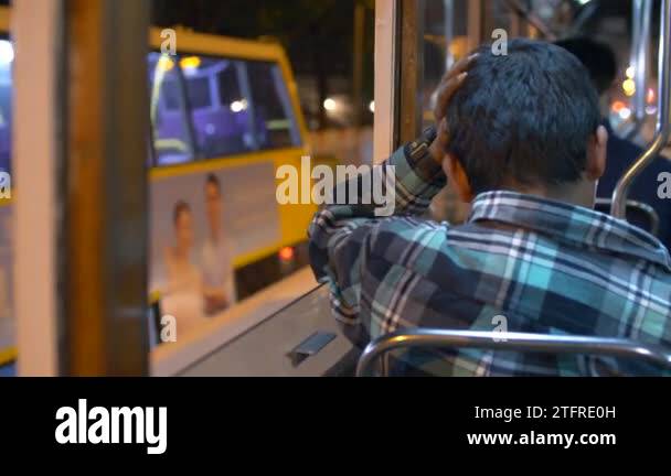 Chinese man in a shirt on a bus sitting alone, shot from behind at ...
