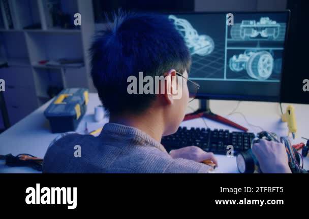 Asian teenager doing Arduino robot homework project in house ...