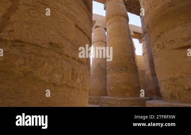 Majestic columns with ancient Egyptian drawings, sun comes out from ...