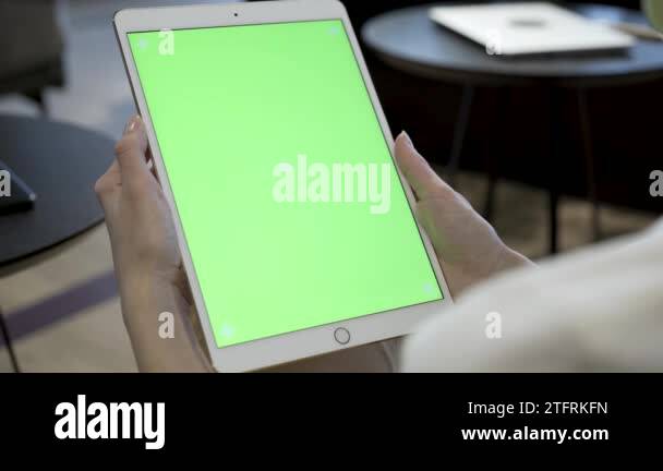 Woman holding iPad tablet device in portrait position. Woman is looking ...