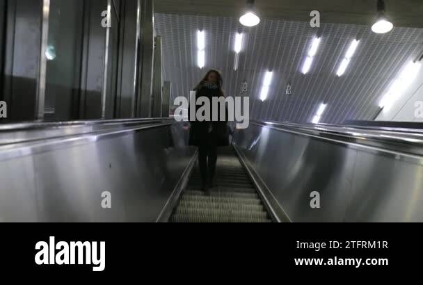 Woman descending on modern electric escalator stairs. Girl walking down staircases in 4K Stock ...