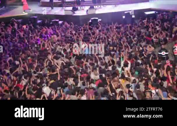 overview of huge crowd of people dancing and clapping his hands during ...