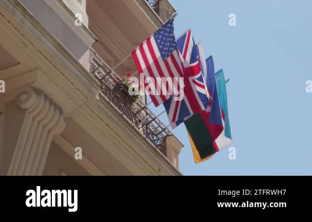 Flags of different world countries waved by wind on balcony of white ...