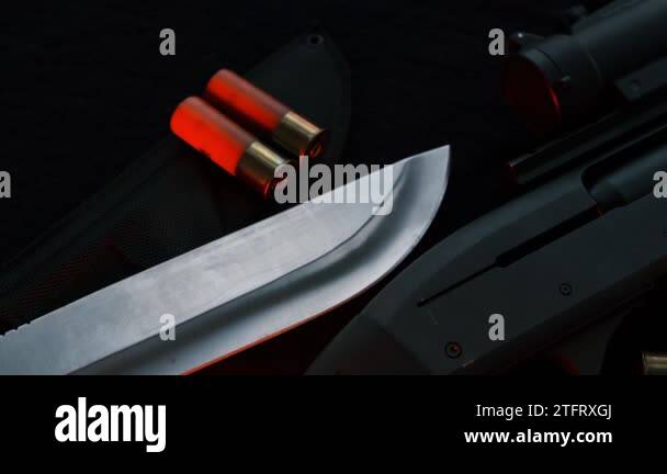 Weapon on black cloth: knife, rifle, shells,top view. Top view of knife ...