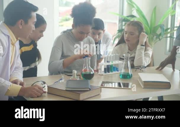 Young teacher teaching group student about science and explaining ...