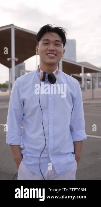 Looking at camera vertical video portrait of an Asian guy. Smiling ...