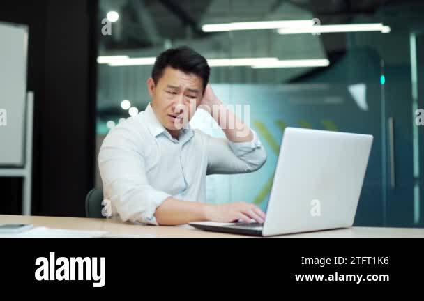 Asian business male employee with pain in the muscles of the neck and ...