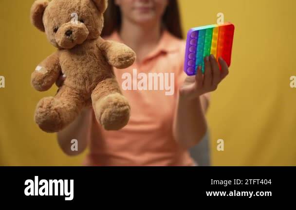 Close-up teddy bear and fidget toy in female Caucasian hands showing ...
