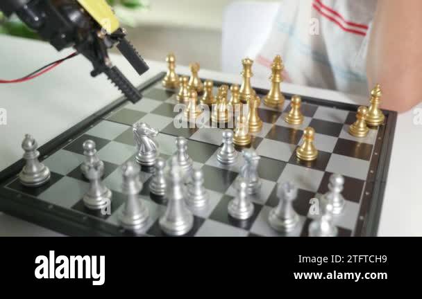 Asian little boy is playing chess with robot machine arm, STEM ...
