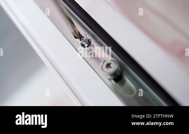 Assembly of plastic doors. A screwdriver twists a screw into the body ...