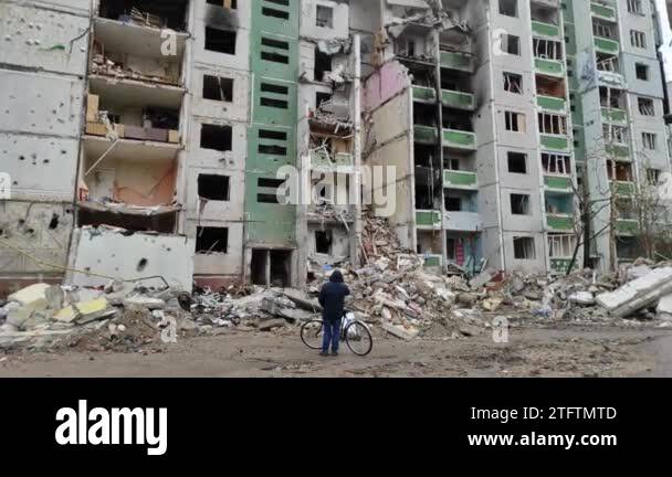 Rear view of a man standing outside a destroyed building following an ...