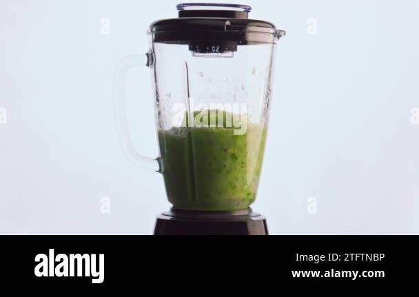Blending green vegetable smoothie in electric mixer close up. Fresh ...