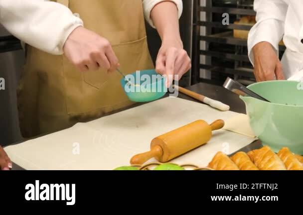 In close-up shots in culinary course class, a uniform chef student with ...