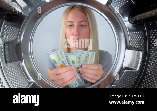 housewife counts money near washing machine and leaves them to wash ...