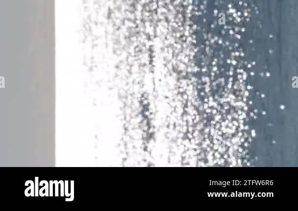 Abstract blurred background.Spots of white reflections of shining sun on blue surface of sea ...