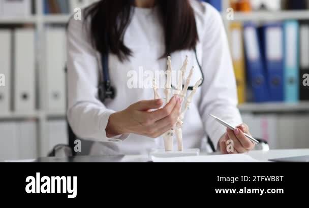 Doctor traumatologist showing pathology of arm on artificial model of ...