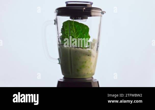 Electric blender mixing vegetable fruits herbs for vitamin cocktail in ...