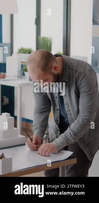 Vertical Video Man Architect Taking Notes On Blueprints Plan To Design Building Structure And