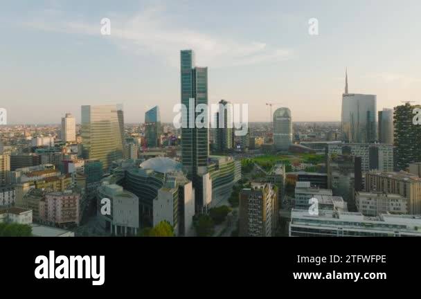 Modern high rise buildings in city at golden hour. Backwards reveal of ...