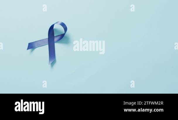 Video of dark blue colon cancer ribbon on pale blue background. medical ...