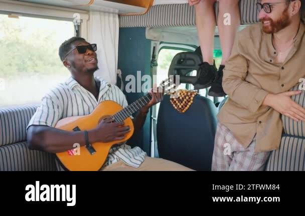 Nomadic group of friends traveling in a van having a little party and ...