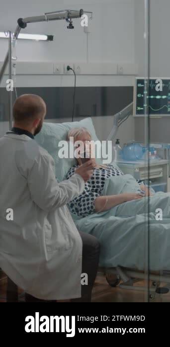 Vertical video: Doctor giving bottle of pills for old patient with ...