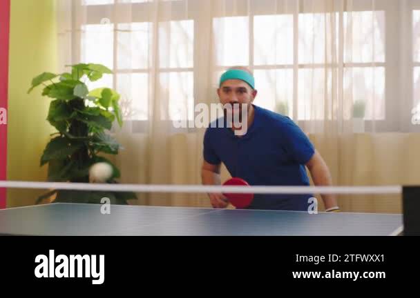 Closeup taking video of a charismatic man ping pong player playing the ...