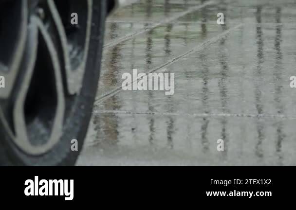 Rain splashing and car tire in rainwater. Car parking in the rain ...