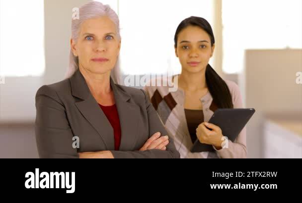 A business executive and her secretary pose for a portrait at work. Two ...