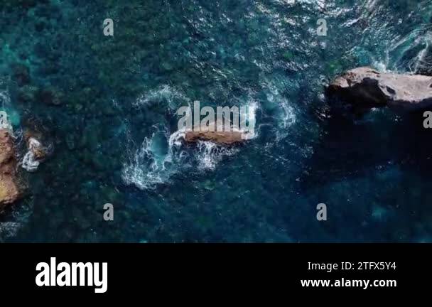 Aerial top view spinning shot of rocky cliff. Indian ocean shore ...