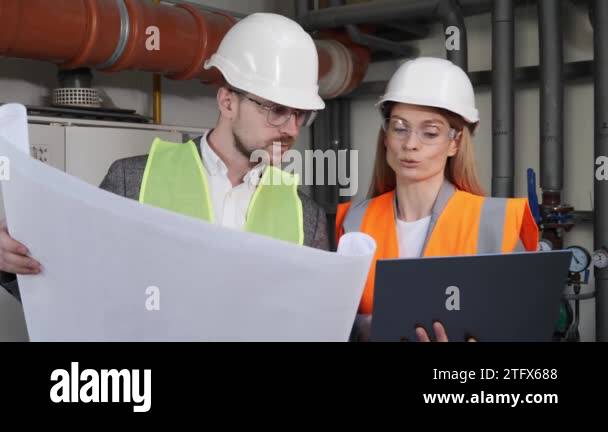 Engineer planning work builders using blueprints and laptop. Building ...