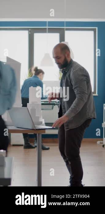 Vertical video: Architectural worker using laptop to design building ...