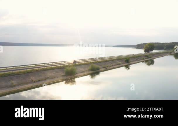 Aerial view to biker riding on motorbike at dam route with sunshine at ...