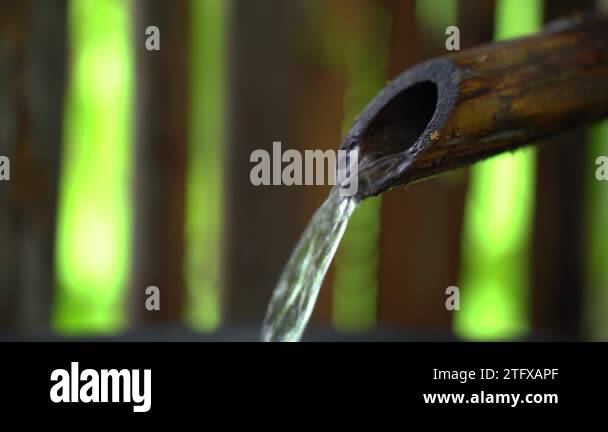 Water flows from the end of the bamboo barrel Stock Video Footage - Alamy