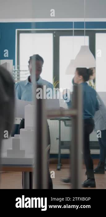 Vertical Video Portrait Of Woman Architect Analyzing Blueprints Plans On Paper To Design