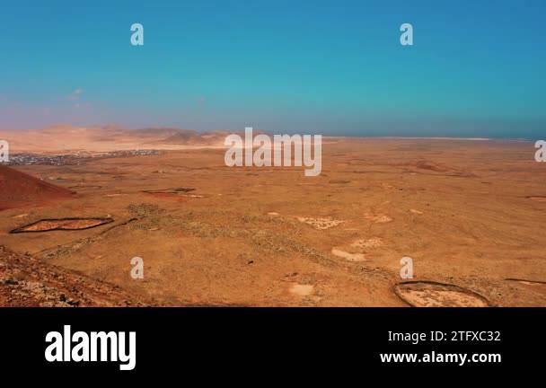 Unrecognizable tourists walk along edge of crater ridge. Spectacular ...