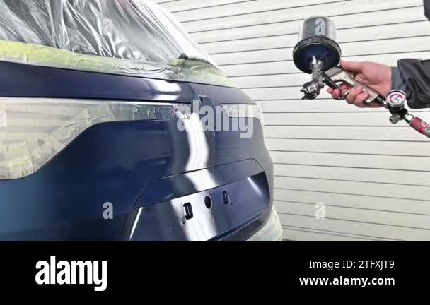 Professional painter cleaning dirty particles using air before spray ...