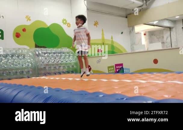 Happy Asian children having fun jump in entertainment center inflatable ...