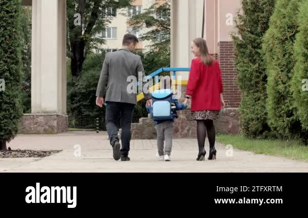 Mom and dad, parents take the child to school, see off and say goodbye ...