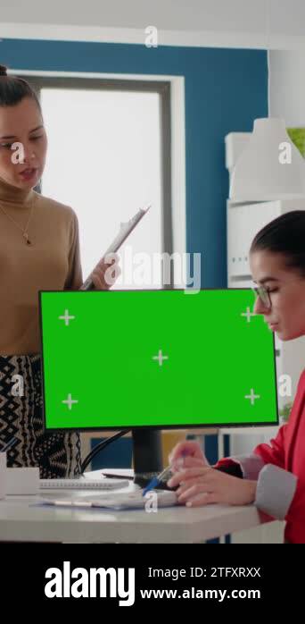 Vertical video: Business people talking about green screen on monitor ...