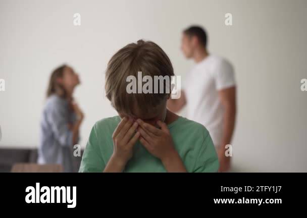 Kid son feels upset while parents fighting at background, sad little ...
