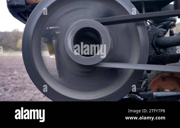 Working process of rotating pulley with belt. Man works in garden with ...