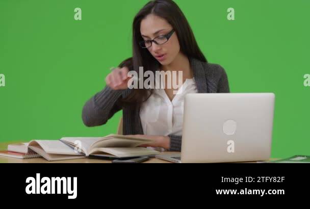 A college student works on her homework on green screen. On green ...