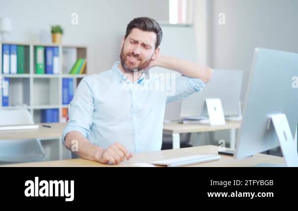 Handsome caucasian male employee with pain in the muscles of the neck ...