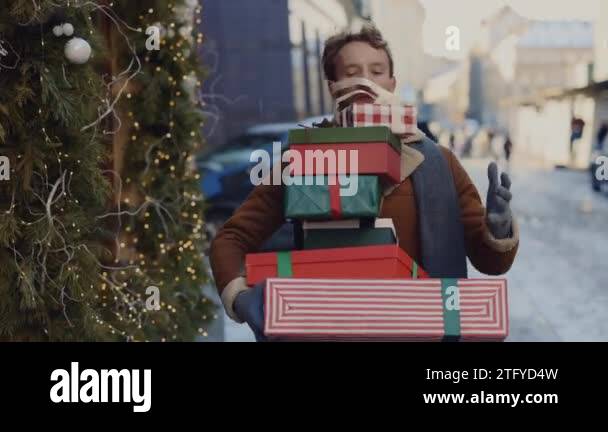 Caucasian man rushly is running home from the gift shop with many boxes ...